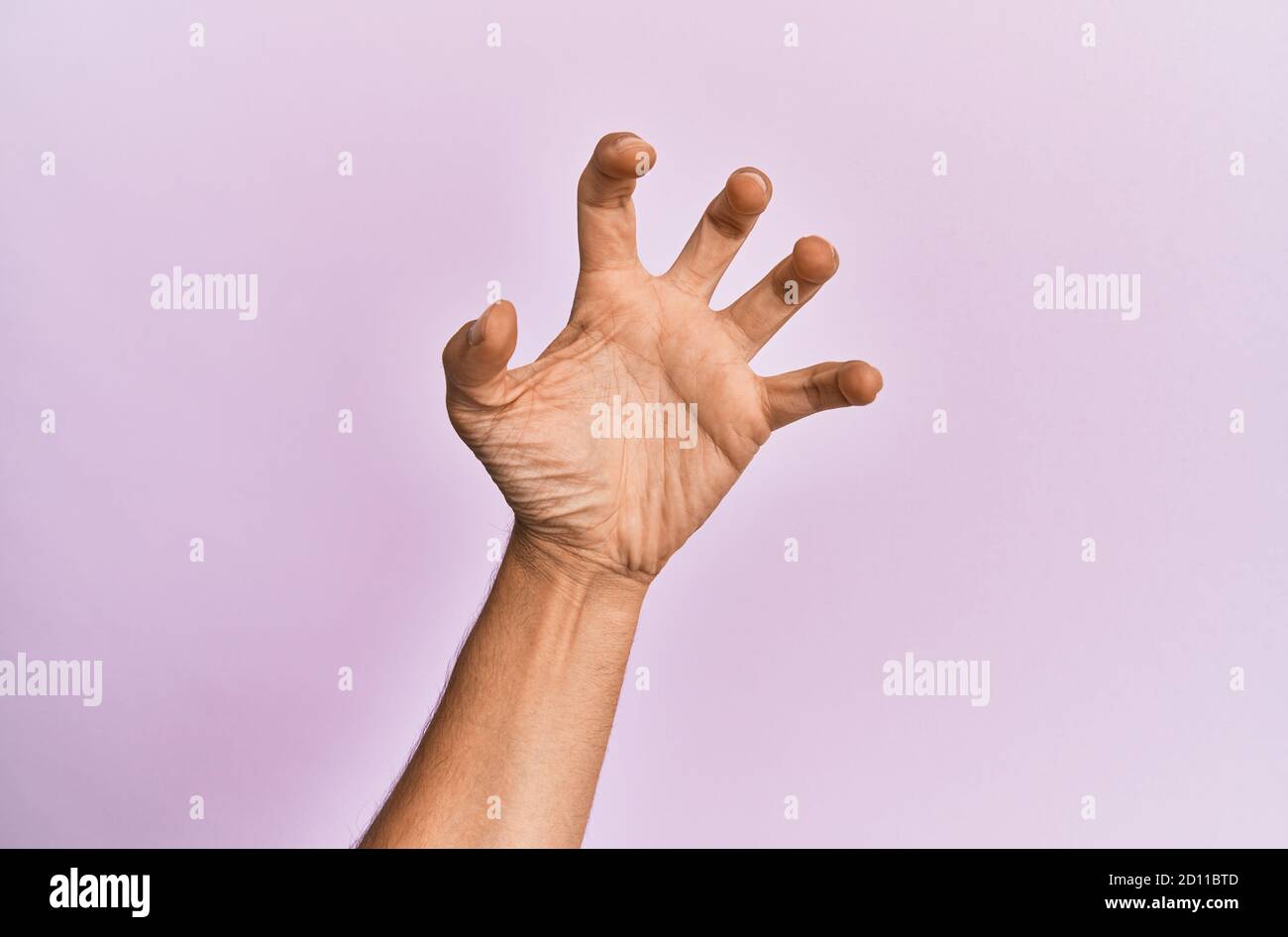 Arm and hand of caucasian young man over pink isolated background ...