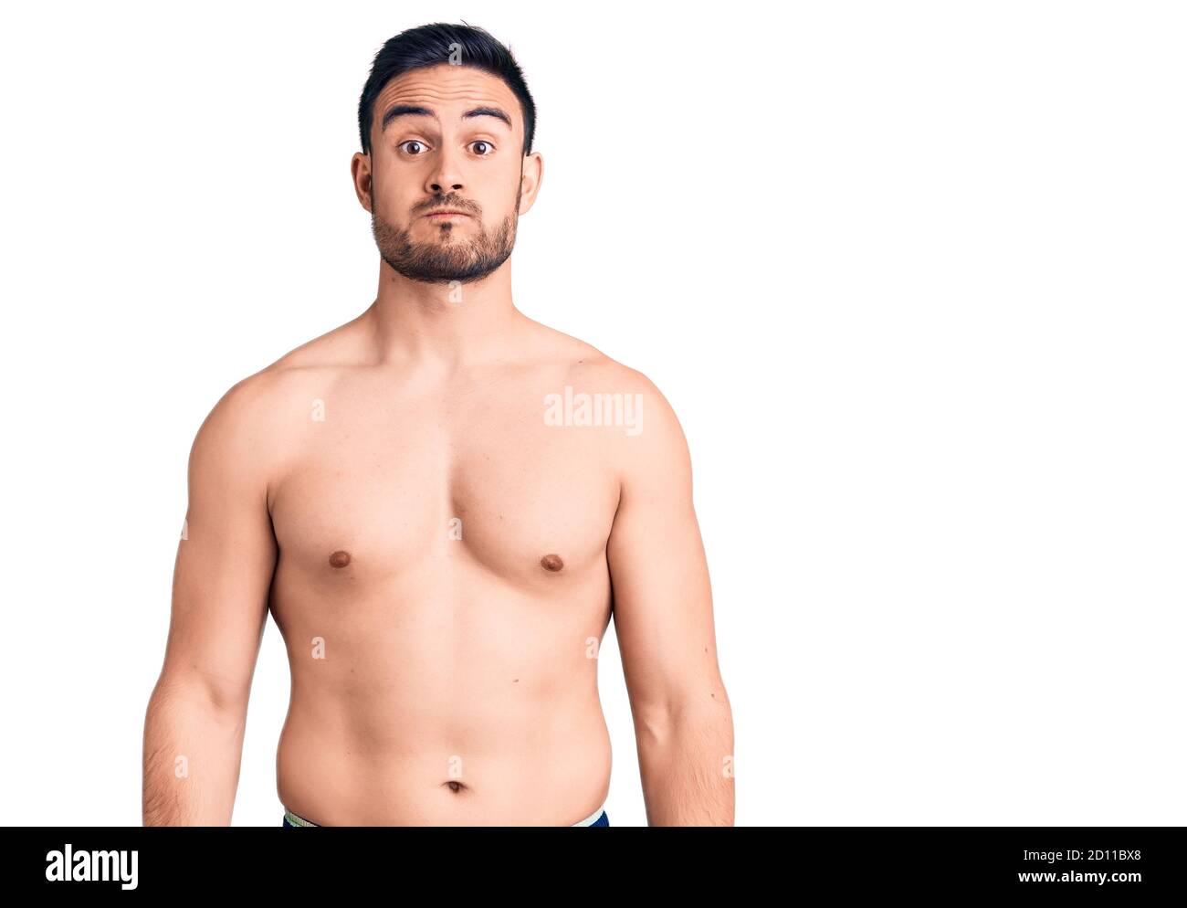 Young handsome man wearing swimwear puffing cheeks with funny face ...