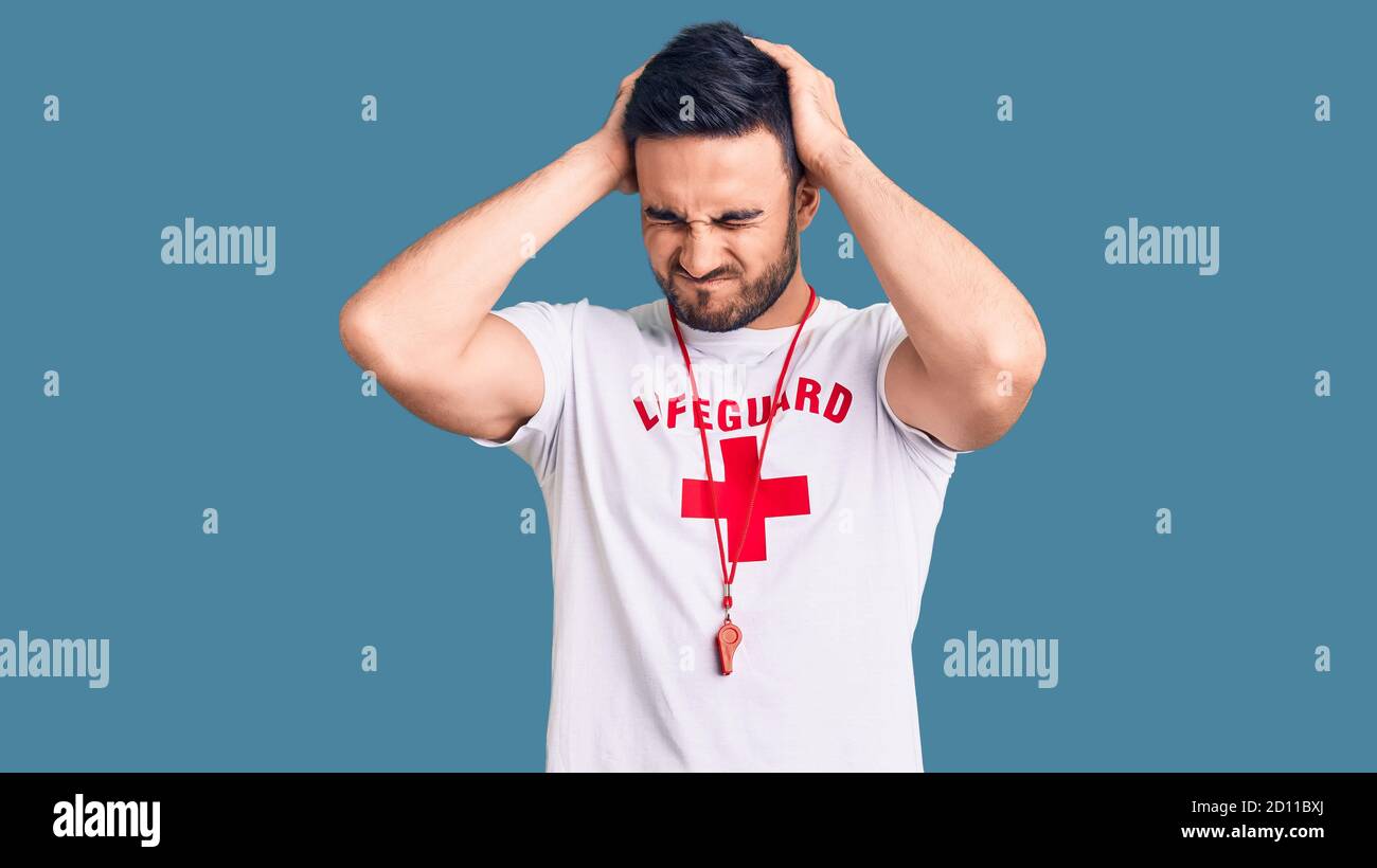 Young handsome man wearing lifeguard uniform suffering from headache ...