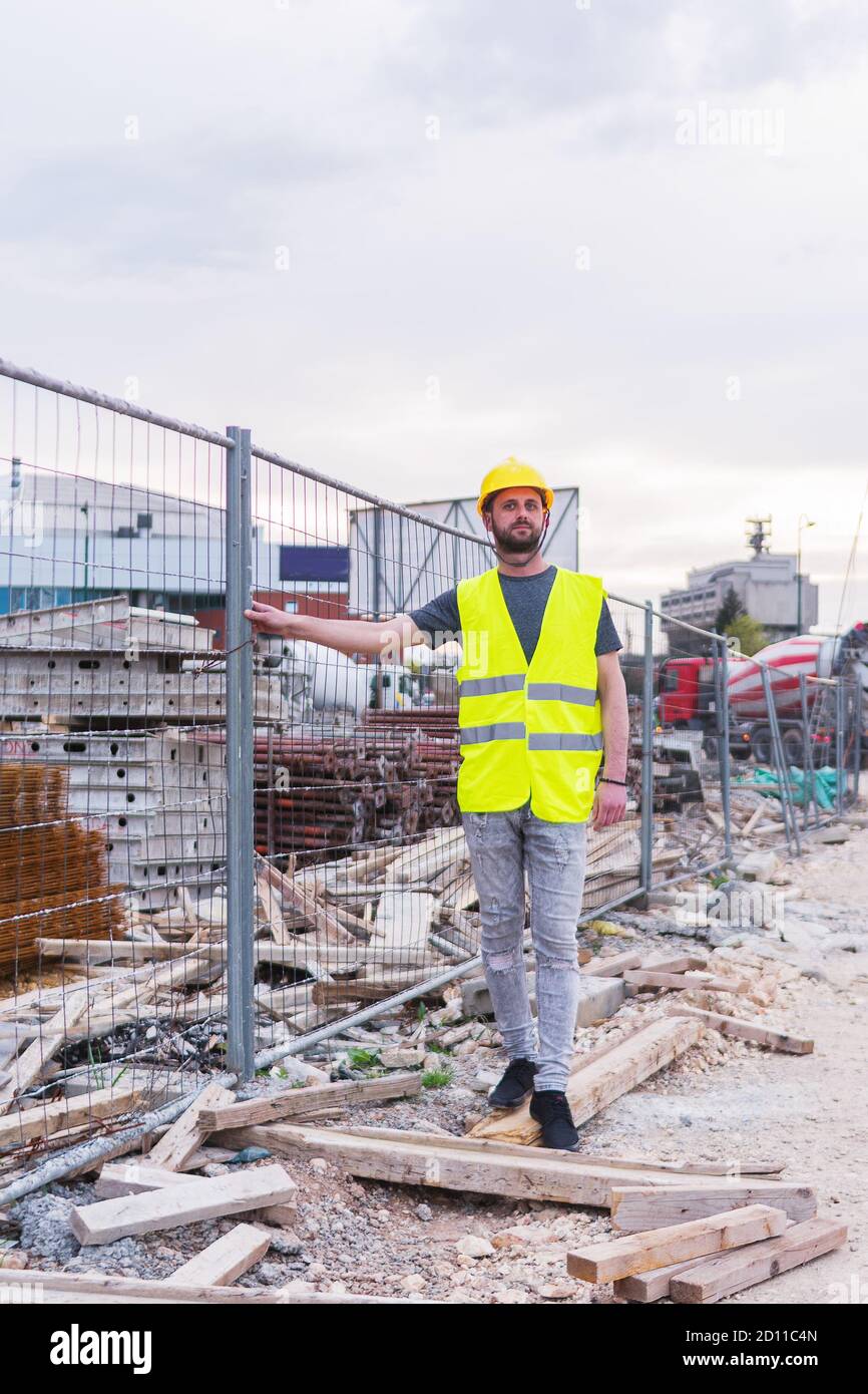 An engineer posing in front of building construction he is working on ...