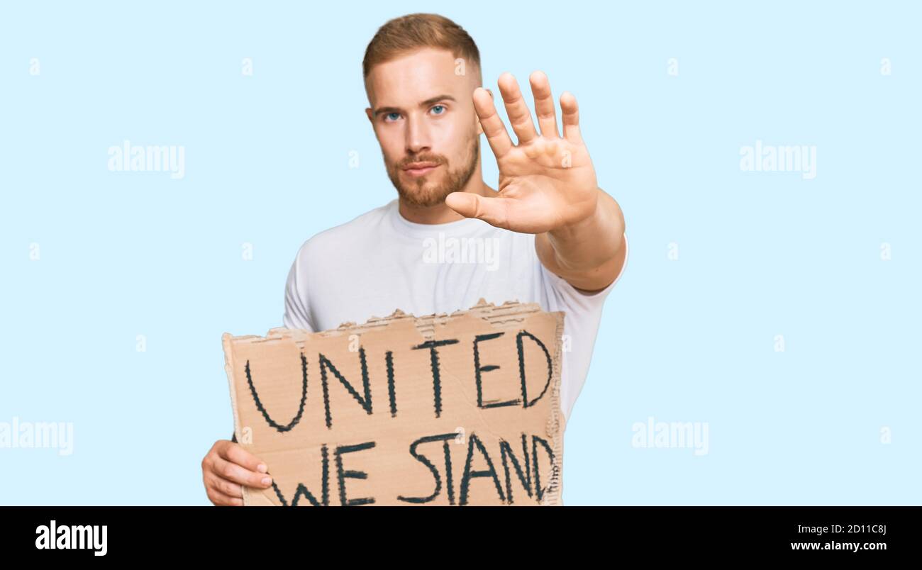 Young irish man holding united we stand banner with open hand doing ...