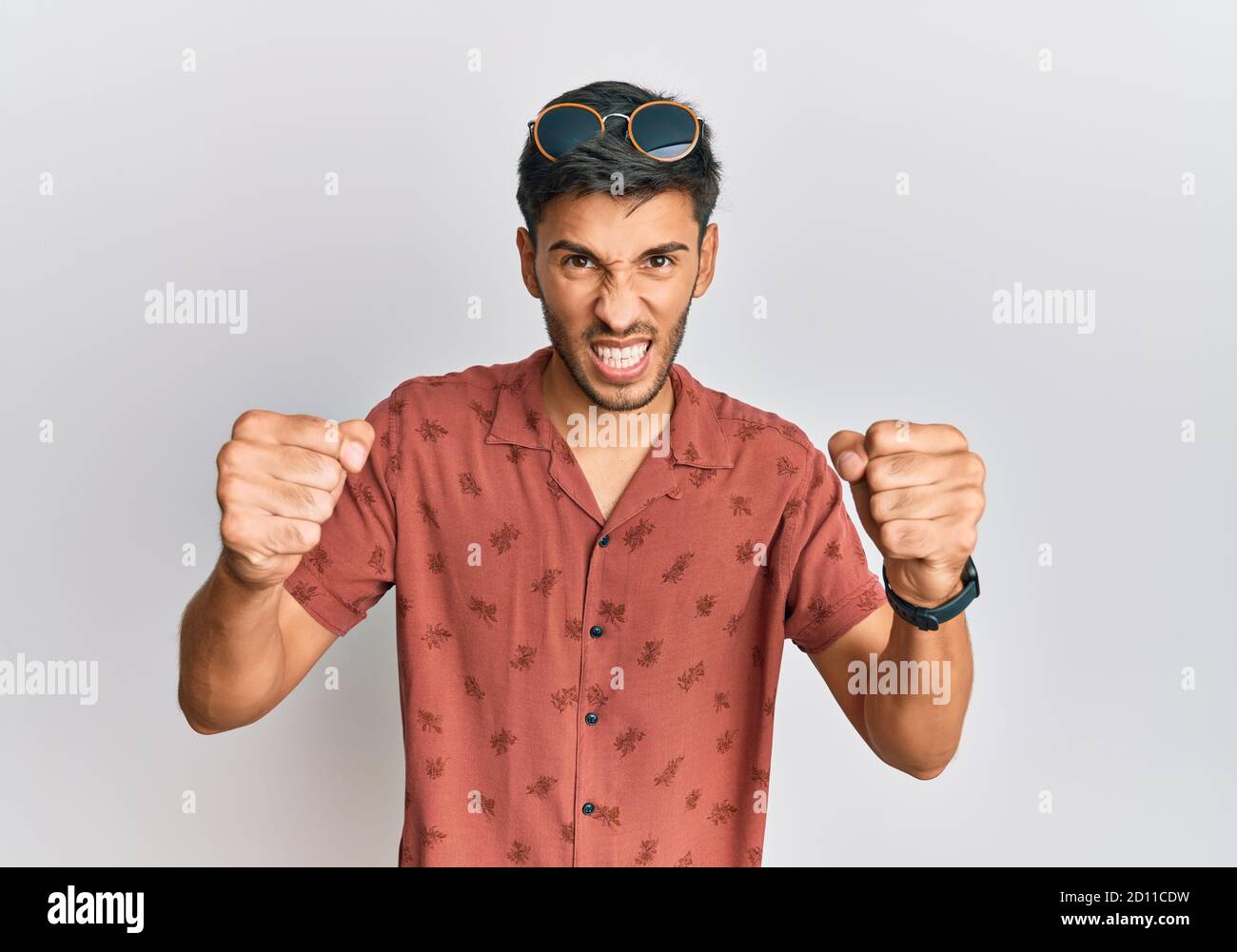 Young handsome man wearing casual summer clothes angry and mad raising ...