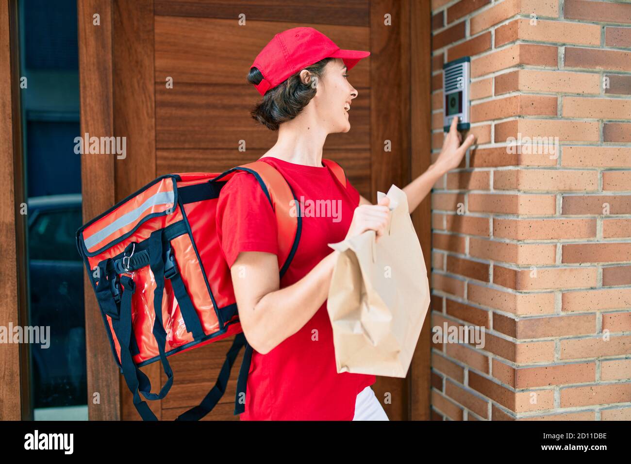 Delivery business worker woman wearing uniform smiling happy knocking ...
