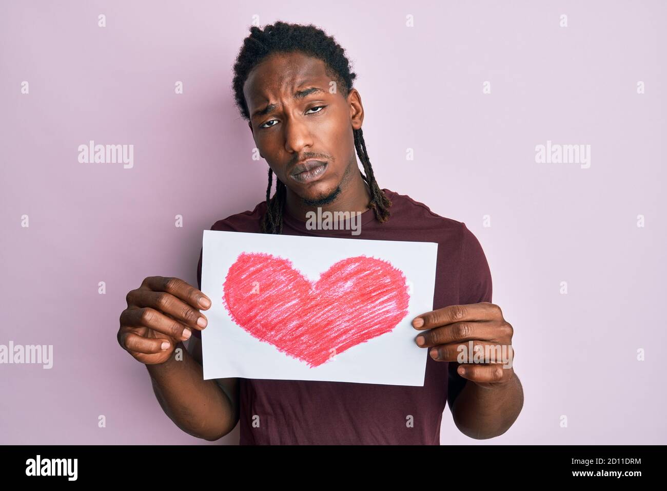 African american man with braids holding heart draw skeptic and nervous ...