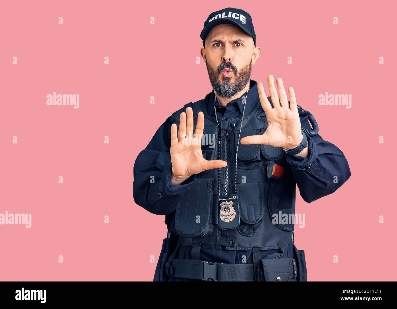 Young handsome man wearing police uniform moving away hands palms ...