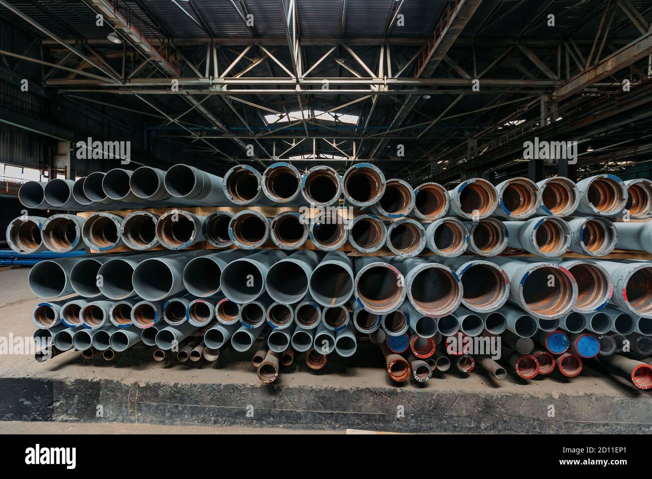 New cast iron pipes for pipeline construction in warehouse Stock Photo ...