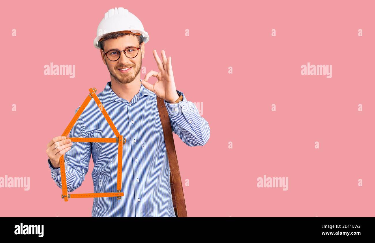 Handsome young man with bear wearing architect hardhat holding build ...