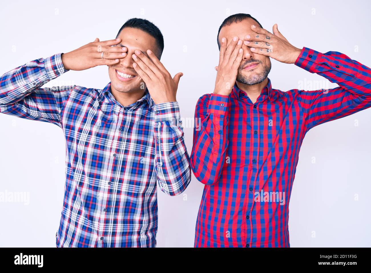 Young gay couple of two men wearing casual clothes covering eyes with ...