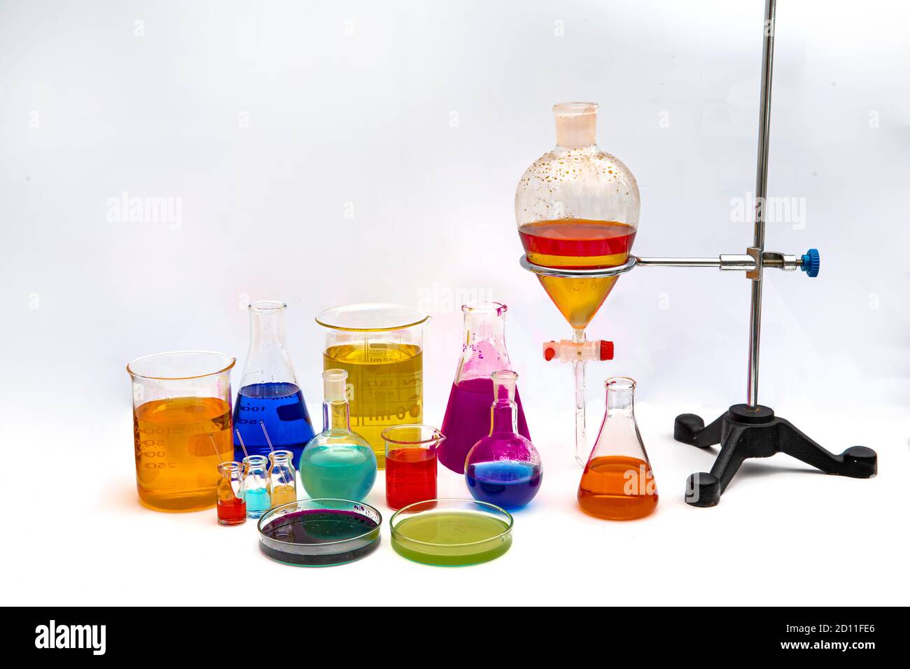 Chemical laboratory glassware with various colored liquids on table ...