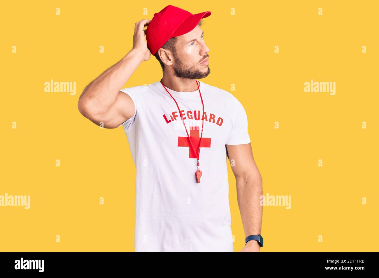 Young caucasian man wearing lifeguard t shirt holding whistle confuse ...