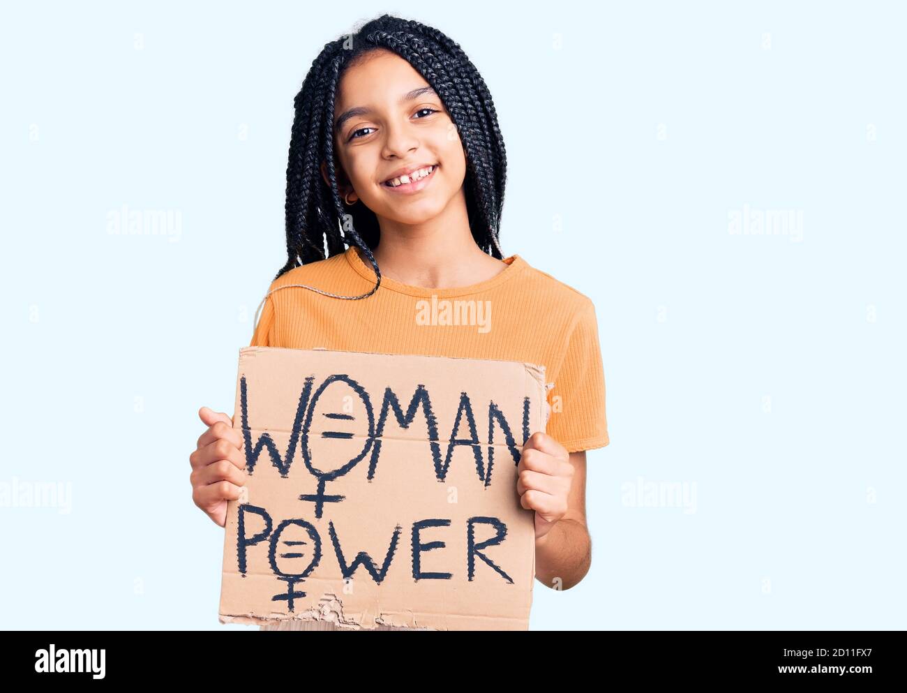 Cute african american girl holding woman power banner looking positive ...