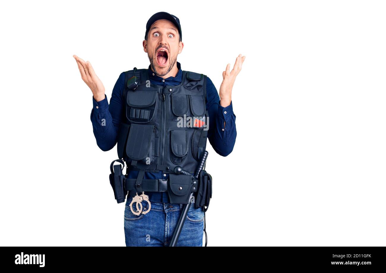 Young handsome man wearing police uniform celebrating crazy and amazed ...