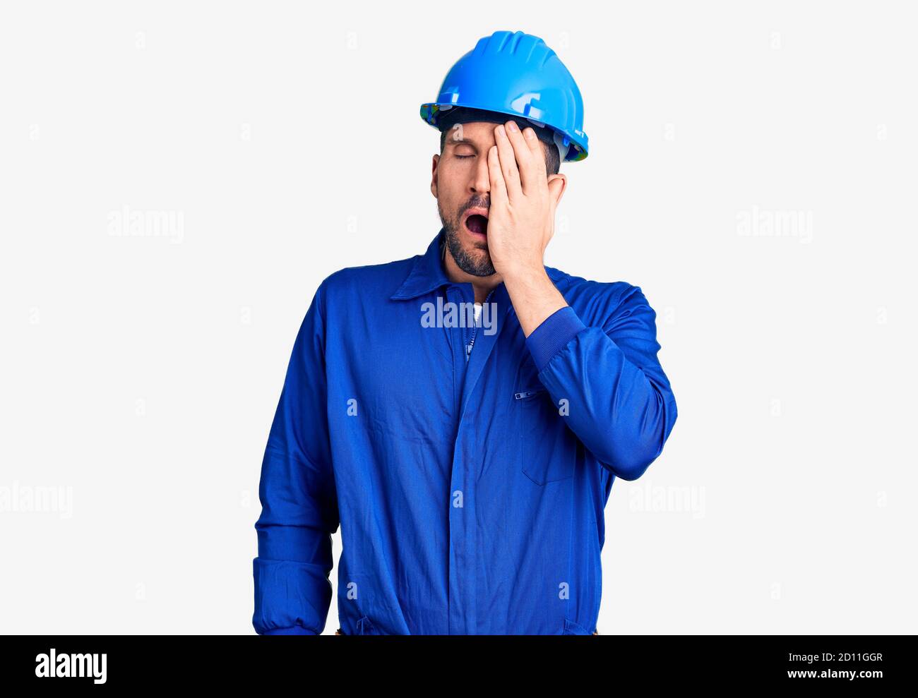 Young handsome man wearing worker uniform and hardhat begging and ...