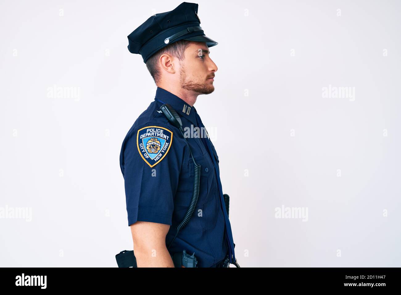 Young caucasian man wearing police uniform looking to side, relax ...