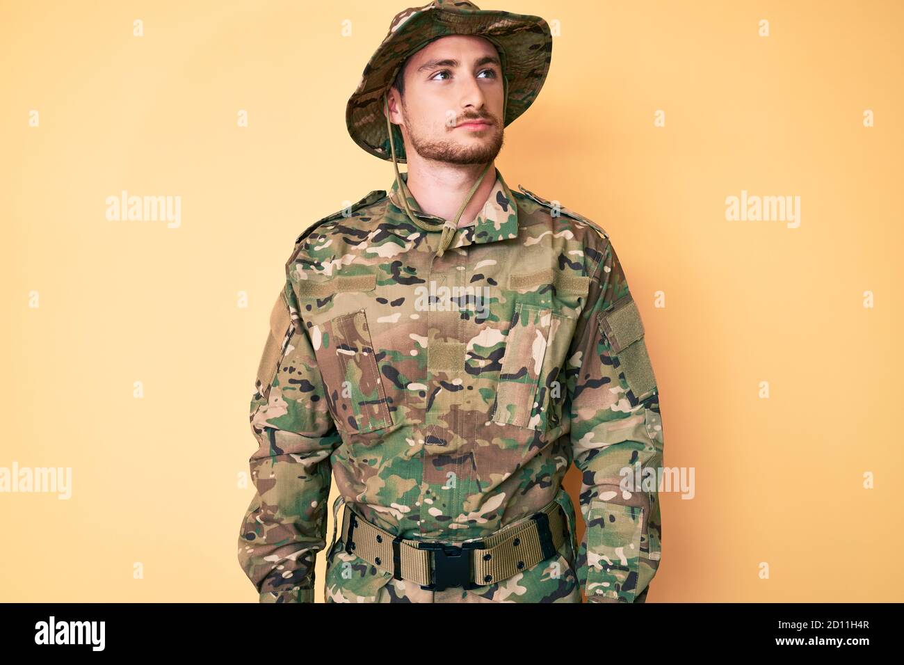 Young caucasian man wearing camouflage army uniform smiling looking to ...
