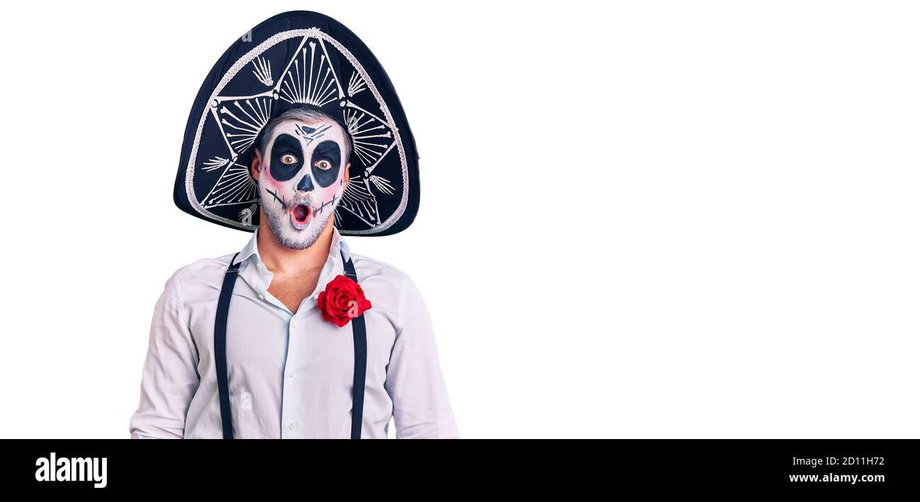 Man wearing day of the dead costume over background in shock face ...