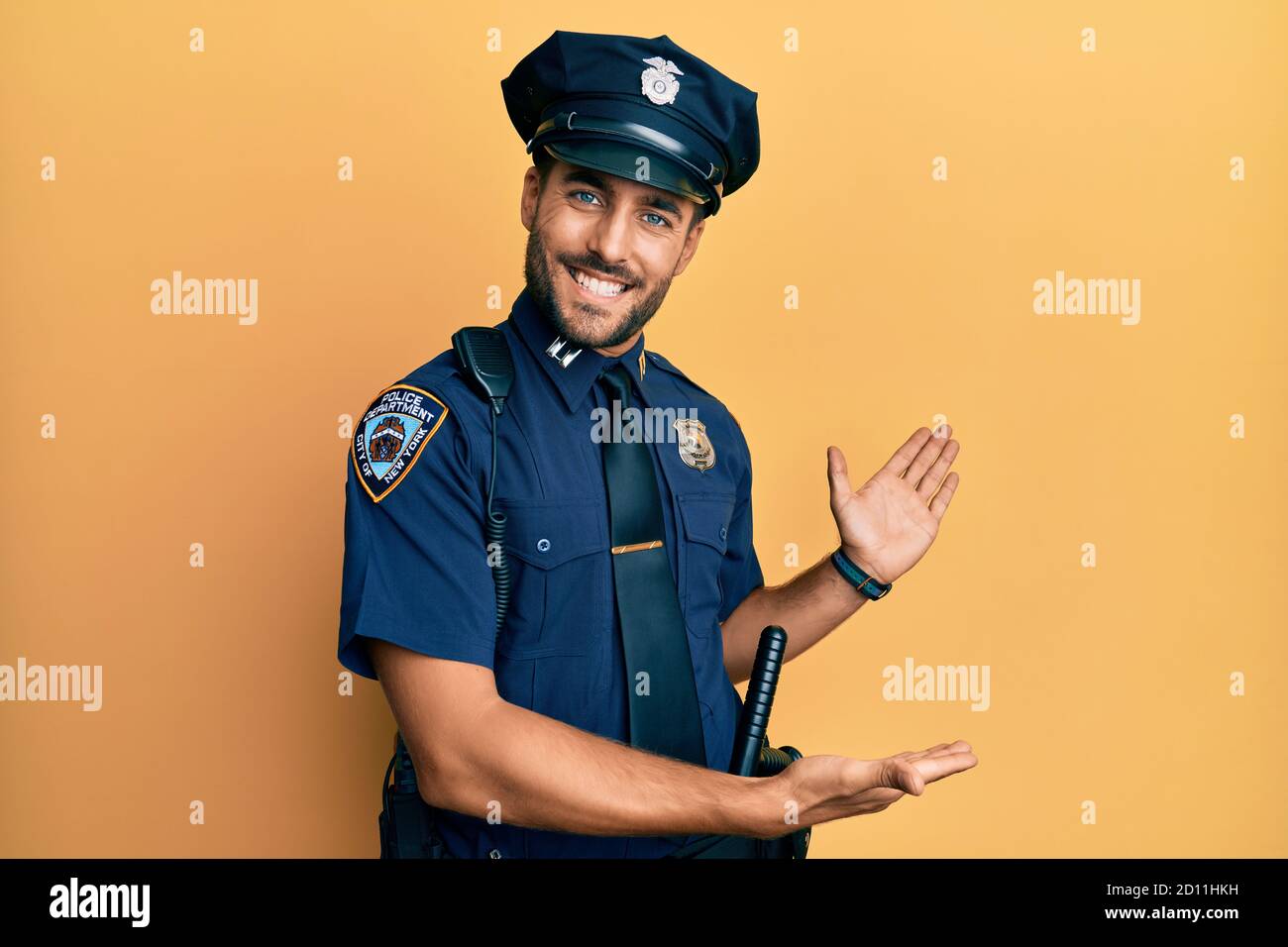 Handsome hispanic man wearing police uniform inviting to enter smiling ...