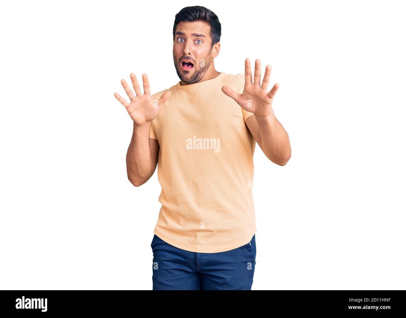 Young hispanic man wearing casual clothes afraid and terrified with ...