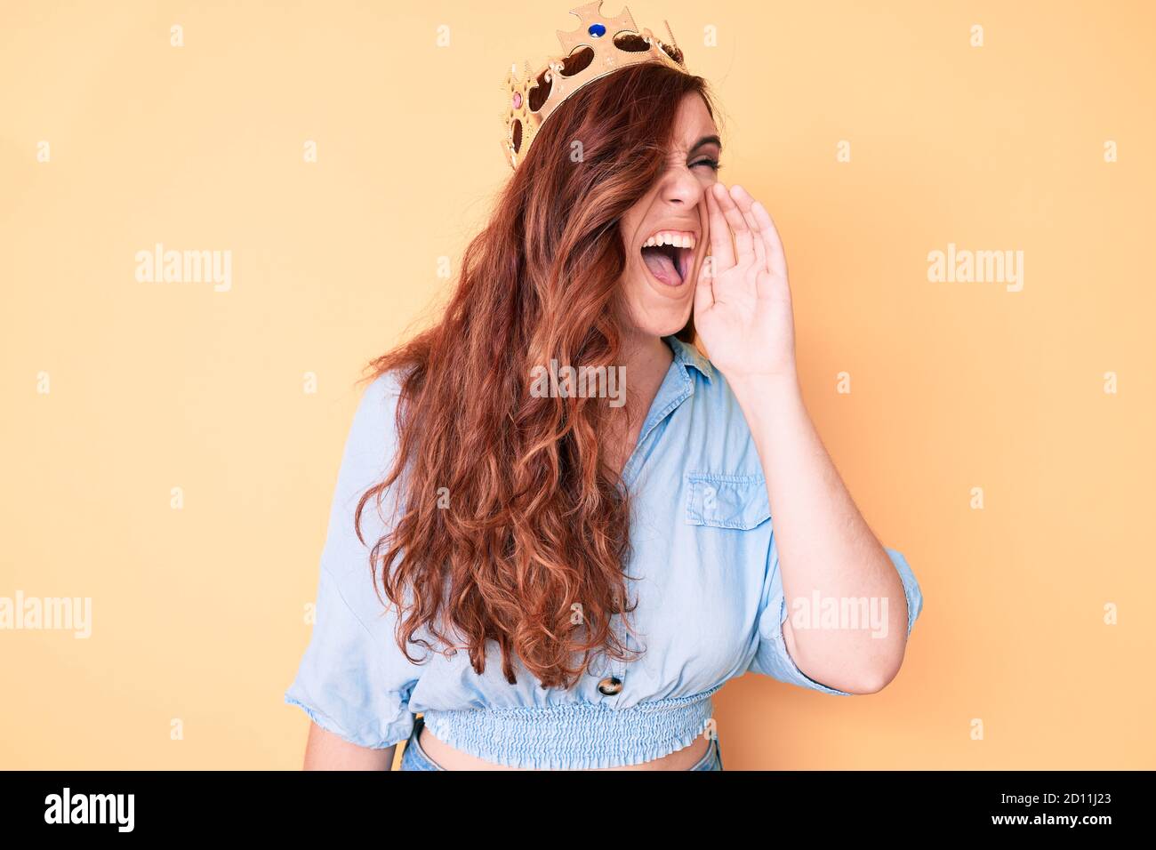 Young beautiful woman wearing princess crown shouting and screaming ...