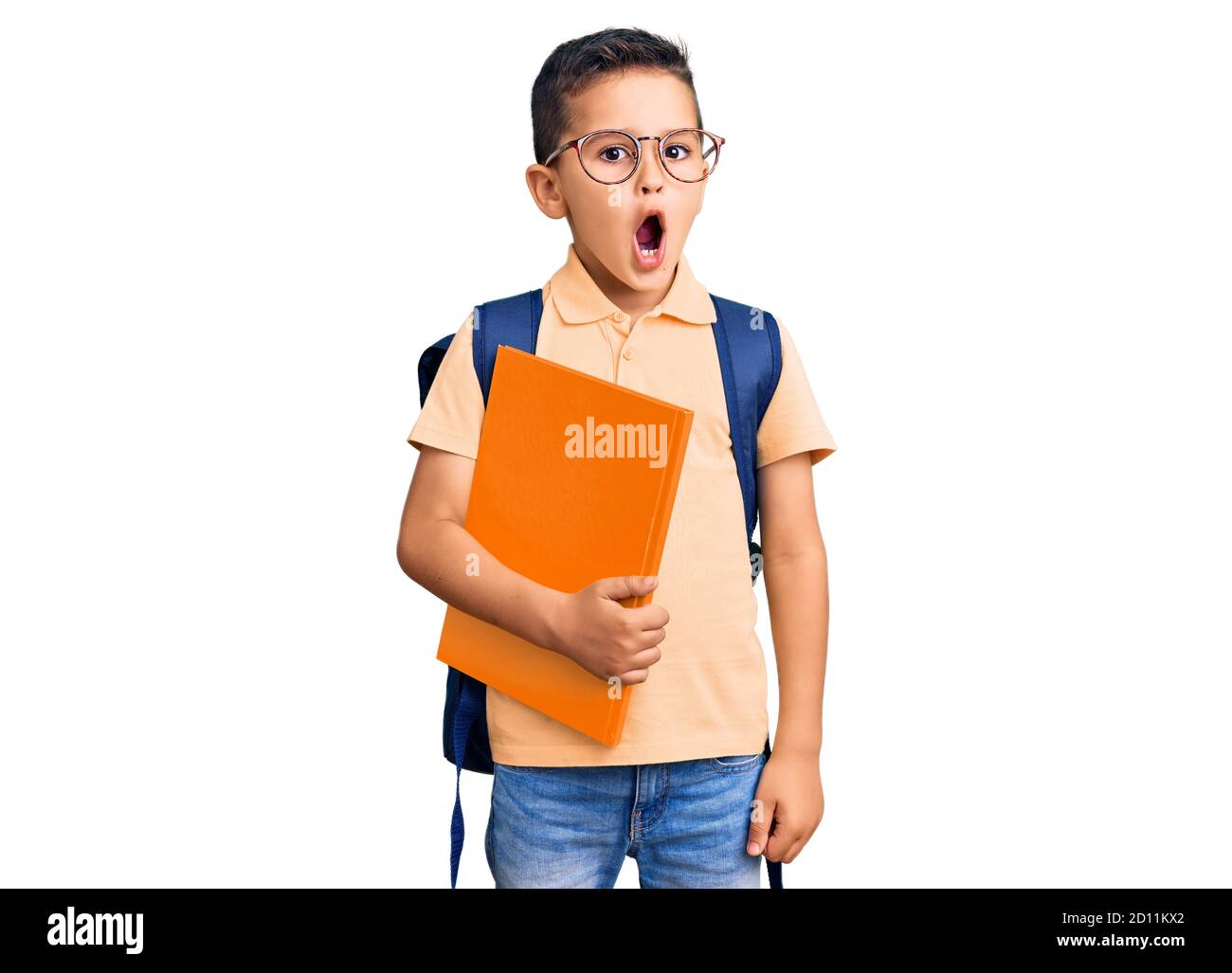 Little cute boy kid wearing school bag and holding book scared and ...