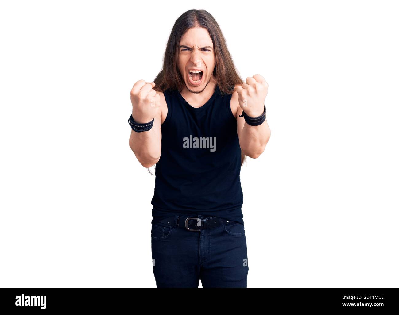 Young adult man with long hair wearing goth style with black clothes ...