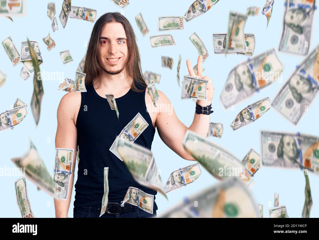 Young adult man with long hair wearing rocker style with black clothes ...