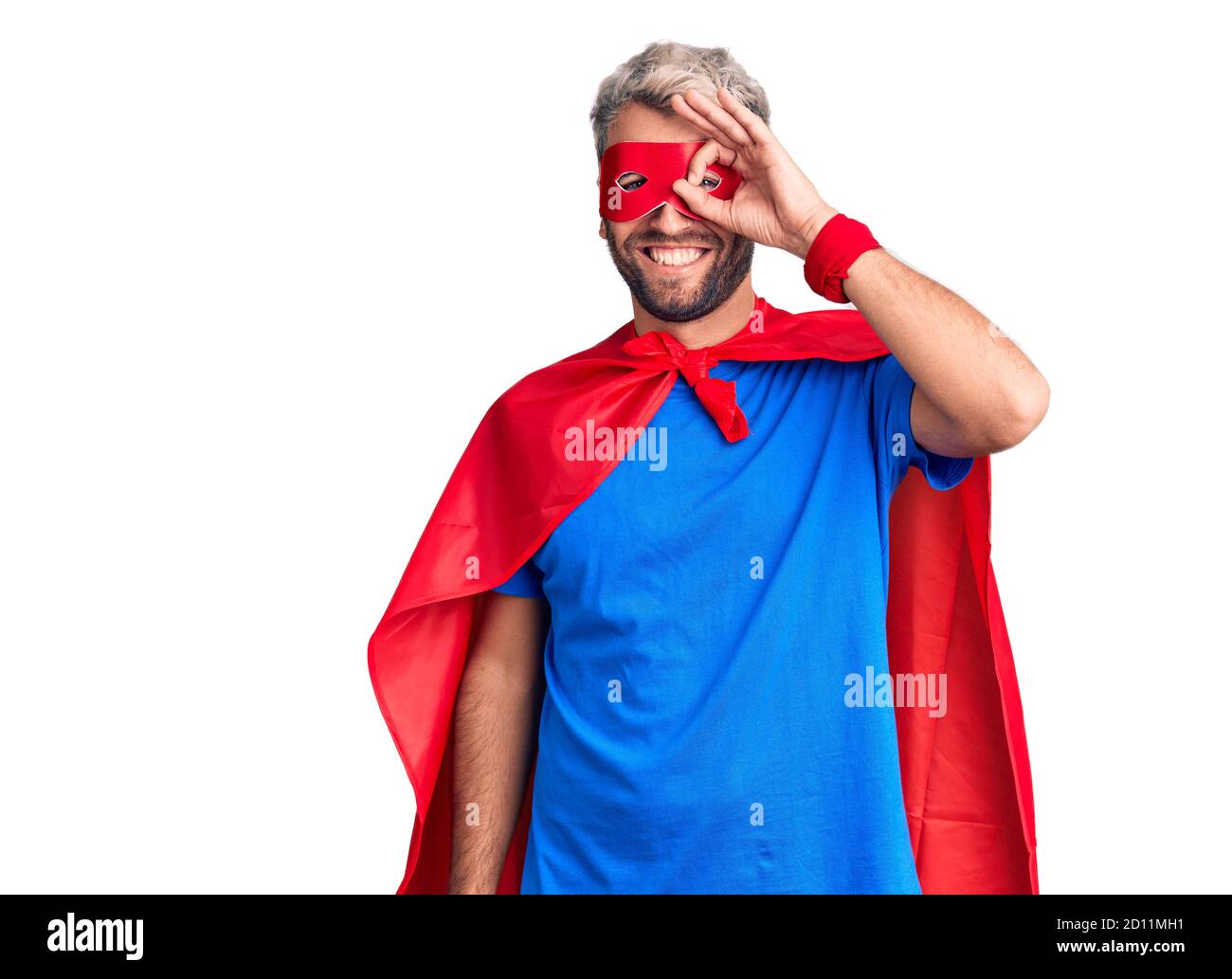 Young blond man wearing super hero custome doing ok gesture with hand ...