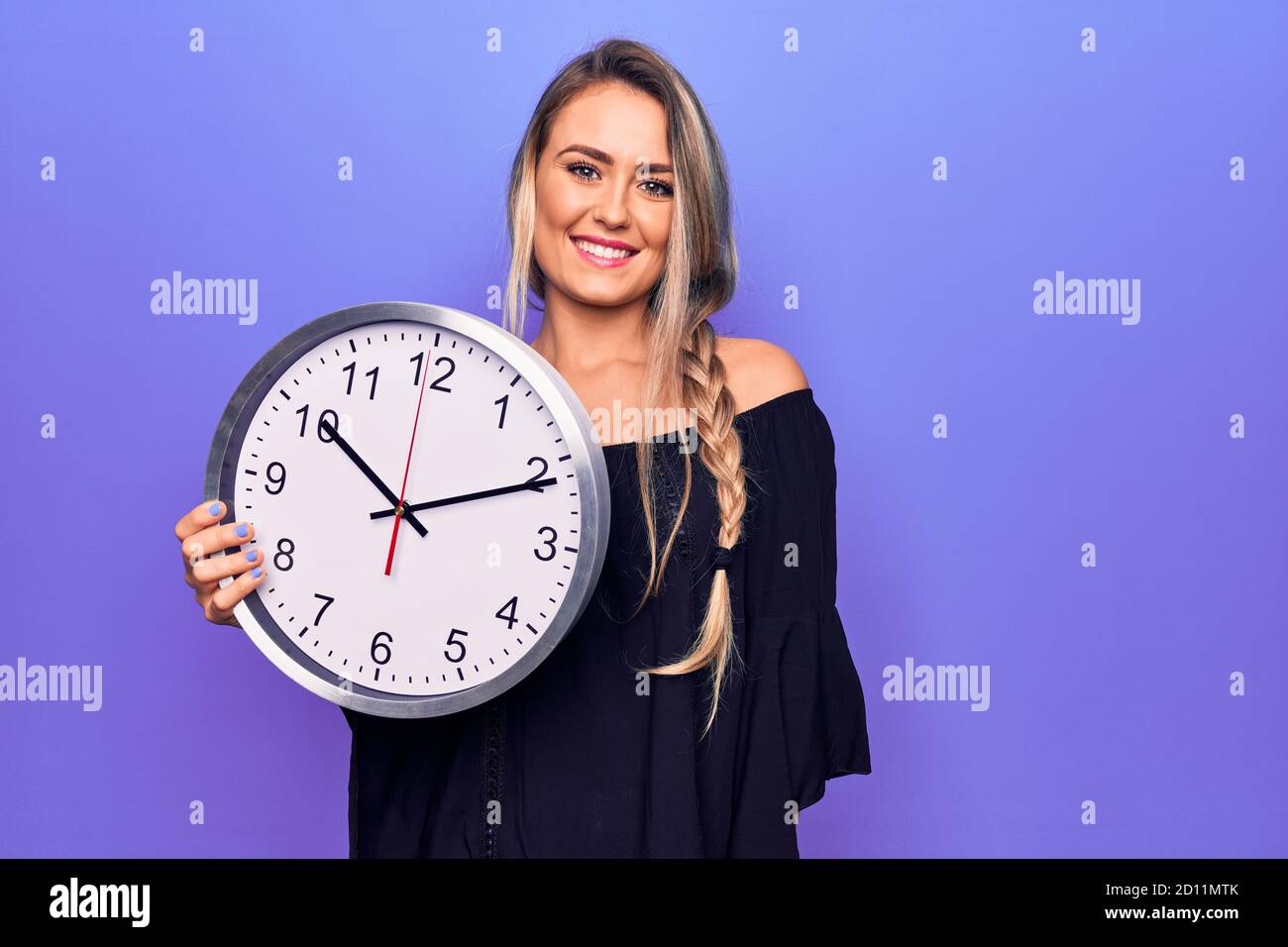 Young beautiful blonde woman doing countdown using big clock over ...