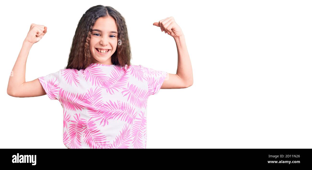Cute hispanic child girl wearing casual clothes showing arms muscles ...