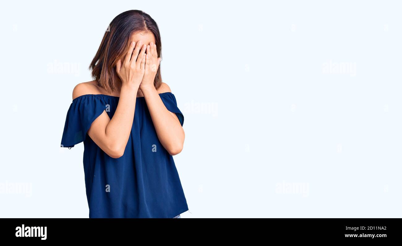 Young beautiful chinese girl wearing casual clothes with sad expression ...