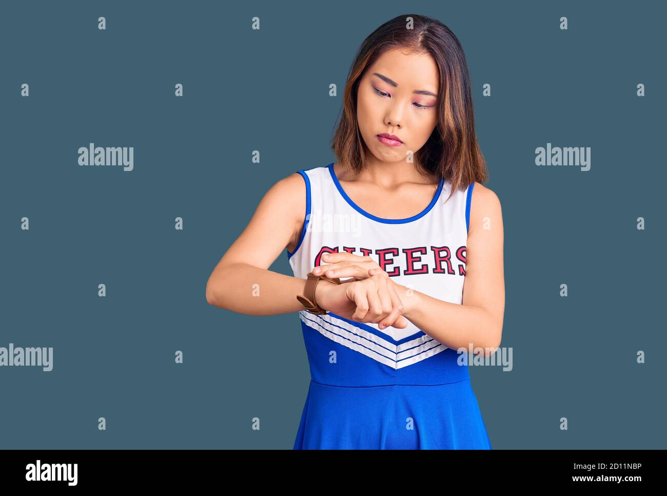 Young Beautiful Chinese Girl Wearing Cheerleader Uniform Checking The