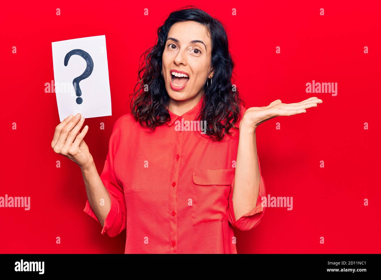Young beautiful hispanic woman holding question mark celebrating ...