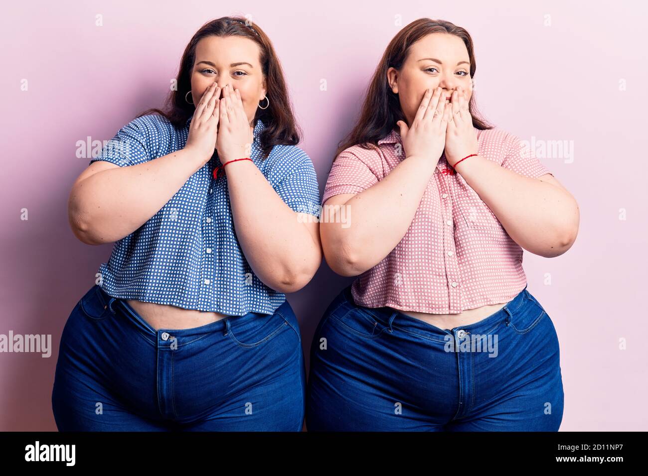 Young plus size twins wearing casual clothes laughing and embarrassed ...