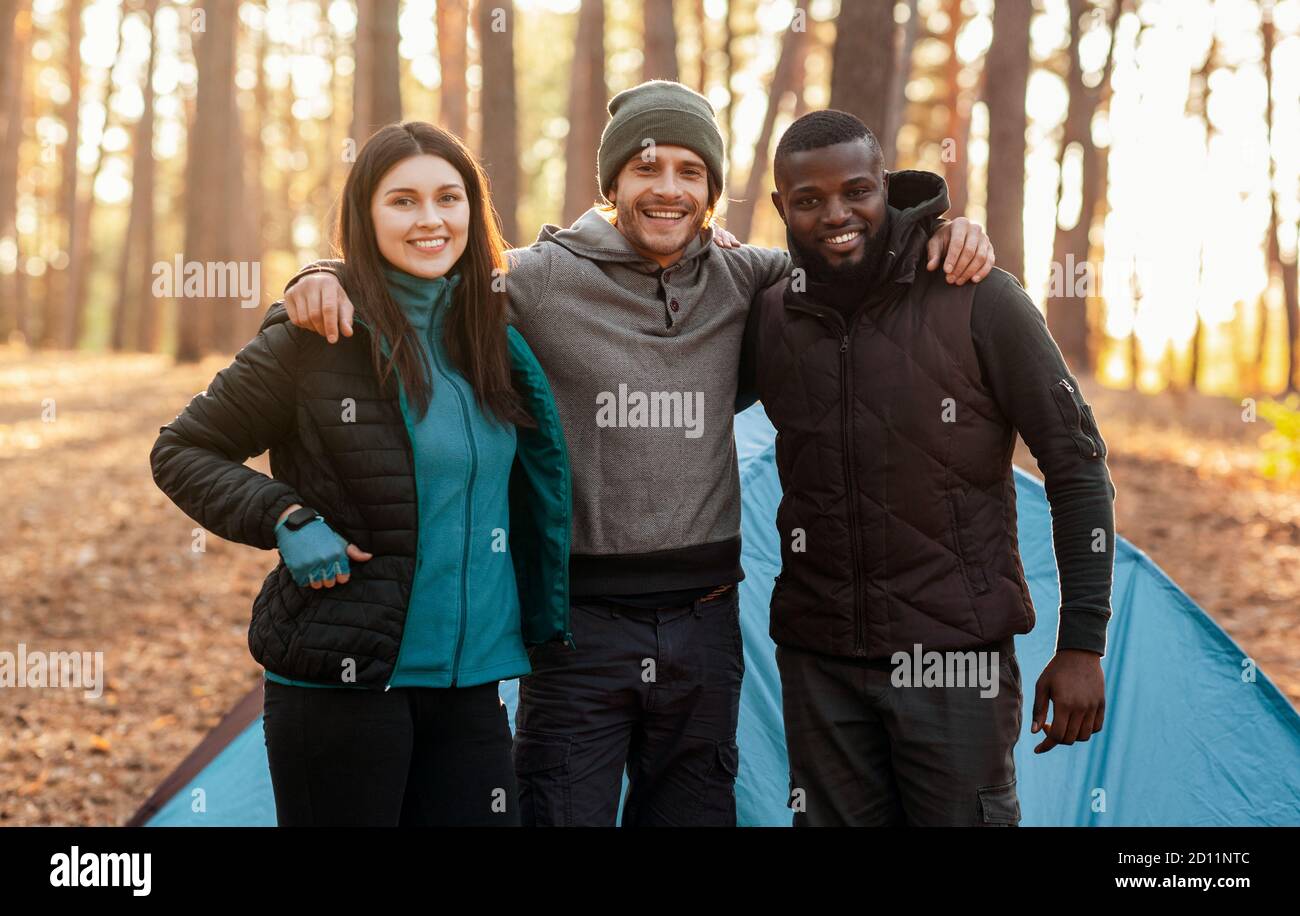 Happy adventurous friends posing over tent in forest Stock Photo - Alamy