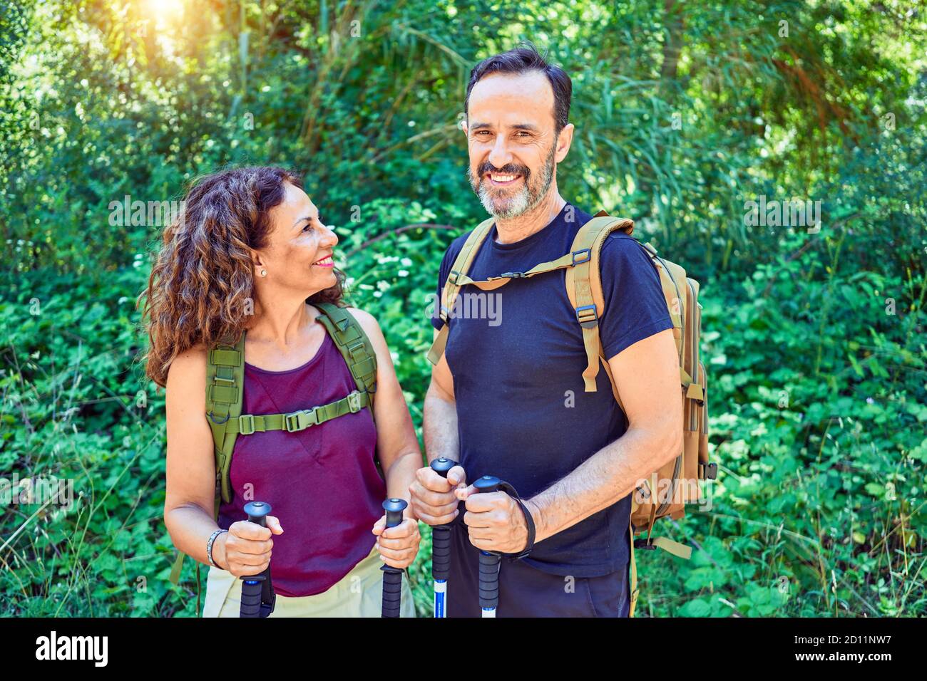 Beautiful couple of hiker wearing backpack smiling happy. Standing with ...