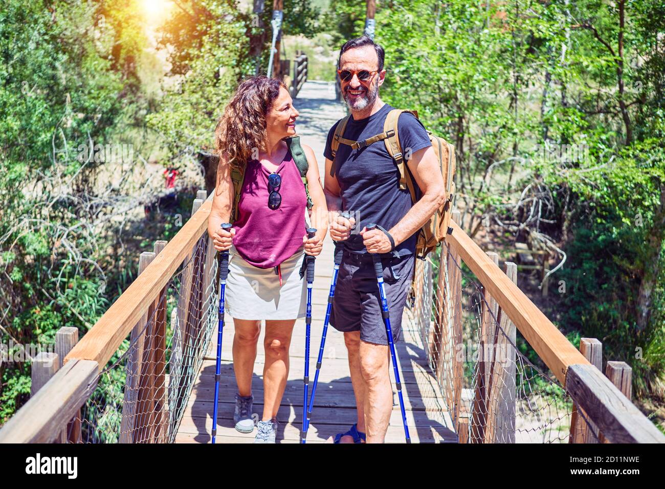 Beautiful couple of hiker wearing explorer clothes and backpack smiling ...