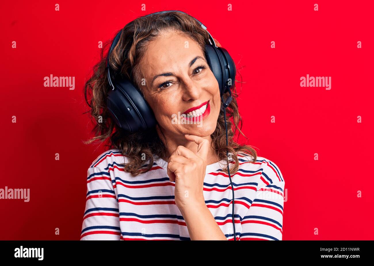 Middle age brunette gamer woman playing video game using headphones and ...