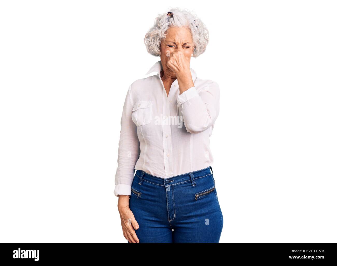 Senior grey-haired woman wearing casual clothes smelling something ...