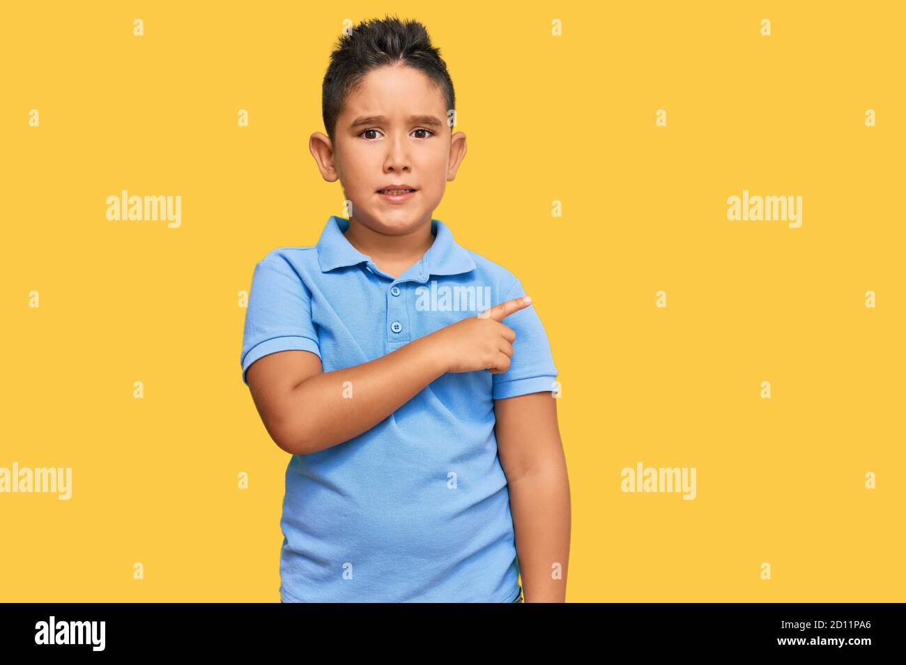 Little boy hispanic kid wearing casual clothes pointing aside worried and nervous with ...