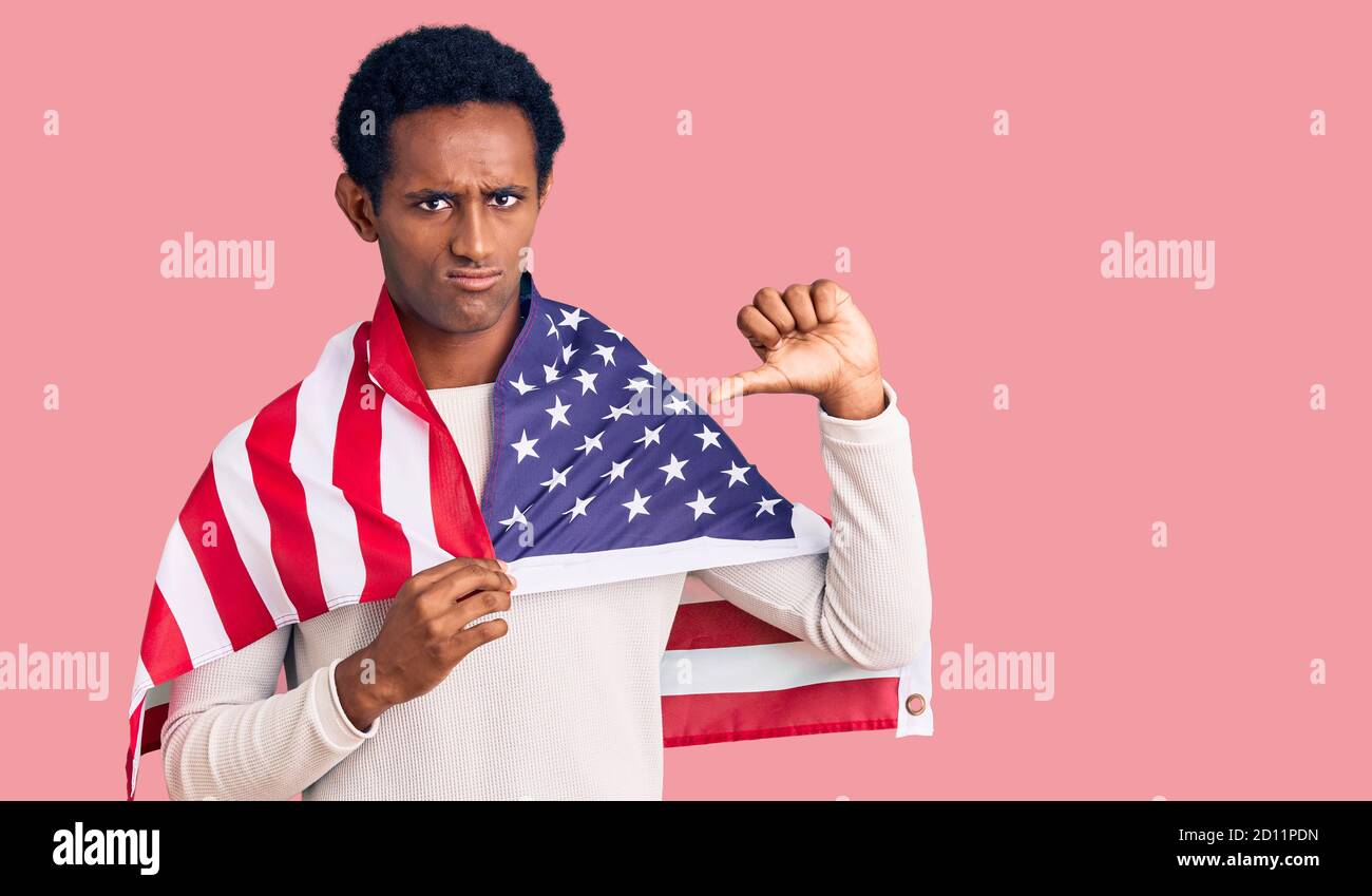 African handsome man holding united states flag with angry face ...