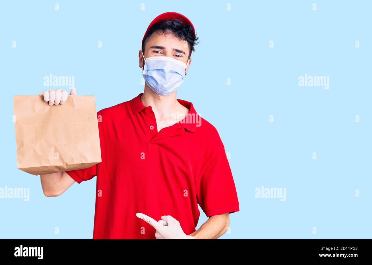 Young Hispanic Man Wearing Delivery Uniform And Medical Mask Holding