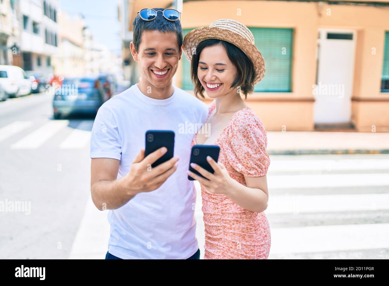 Beautiful couple smiling happy using smartphone at street of city Stock ...