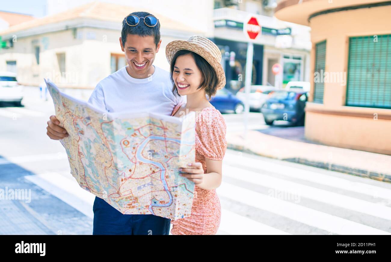 Beautiful couple on vacation smiling happy holding city map at street ...
