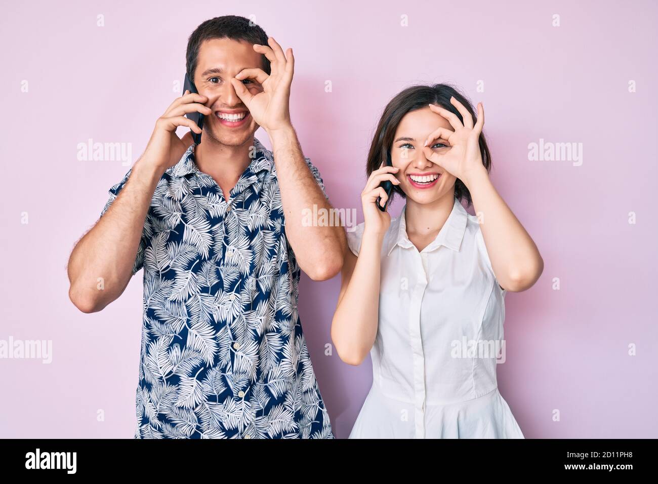 Beautiful couple having conversation talking on the smartphone smiling ...