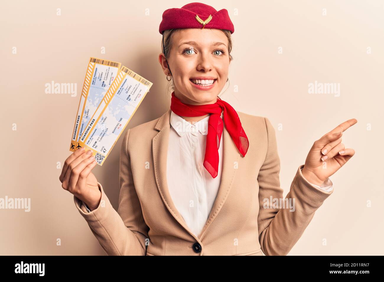 Young beautiful blonde girl wearing stewardess uniform holding boarding ...