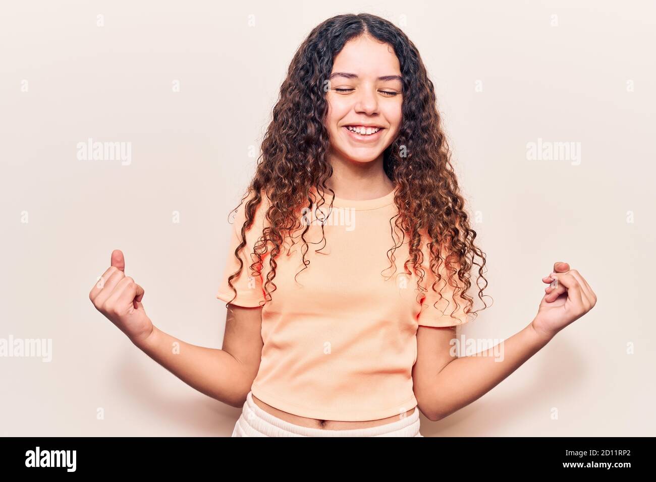 Beautiful kid girl with curly hair wearing casual clothes very happy ...