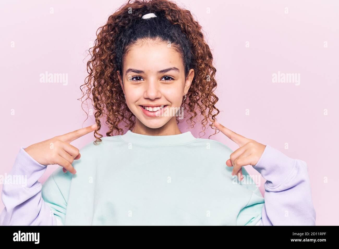 Beautiful kid girl with curly hair wearing casual clothes looking ...