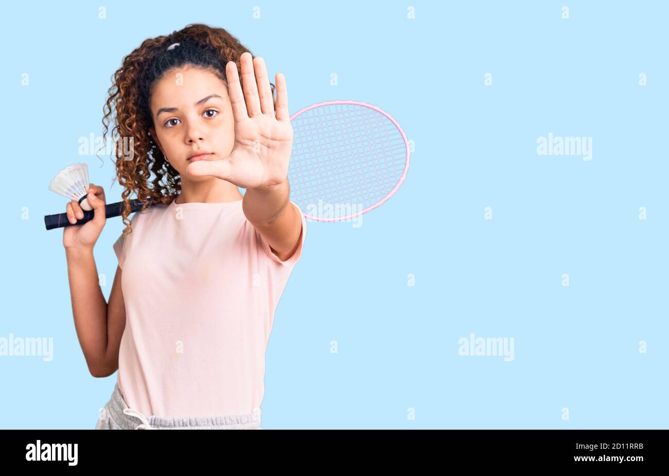 Beautiful kid girl with curly hair holding badminton racket and ...