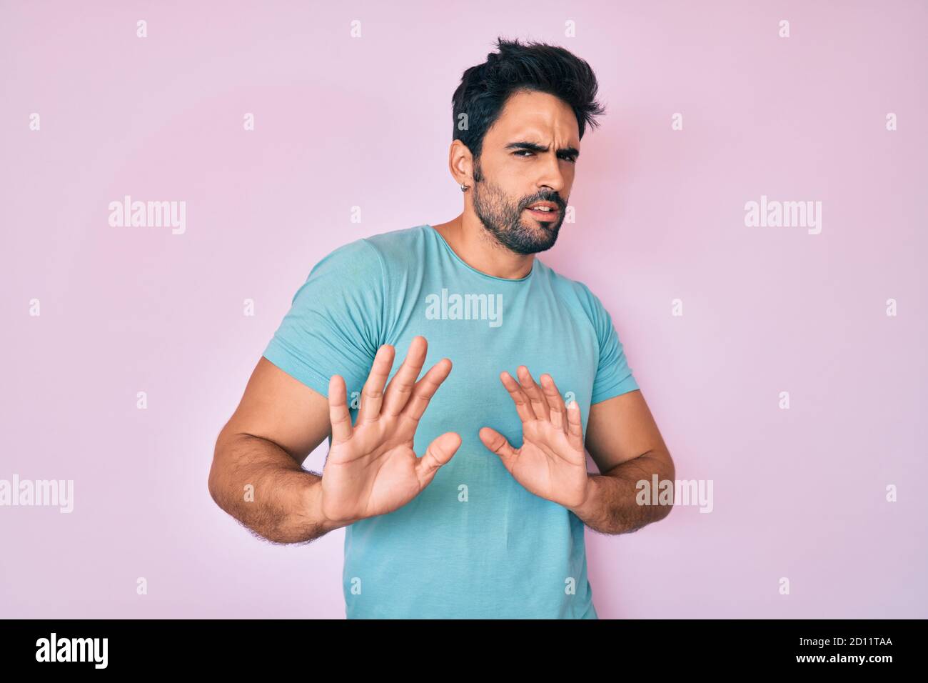 Handsome hispanic man with beard wearing casual clothes disgusted ...