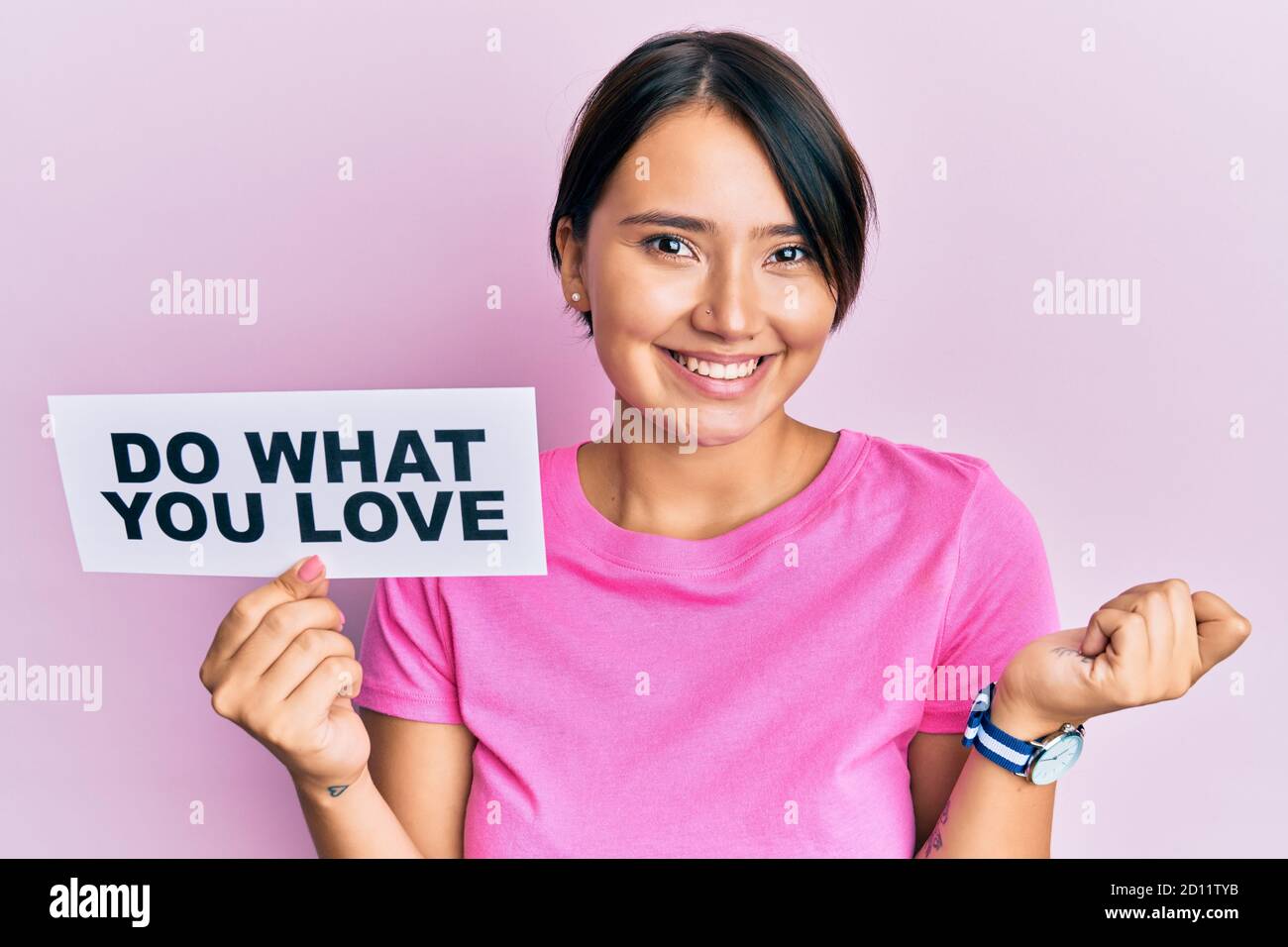 Beautiful young woman with short hair holding paper with do what you ...